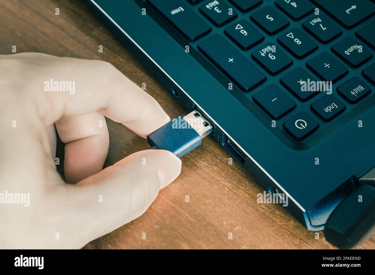 Male Hand Connecting A Black USB Cable To The USB Port Of A Black ...