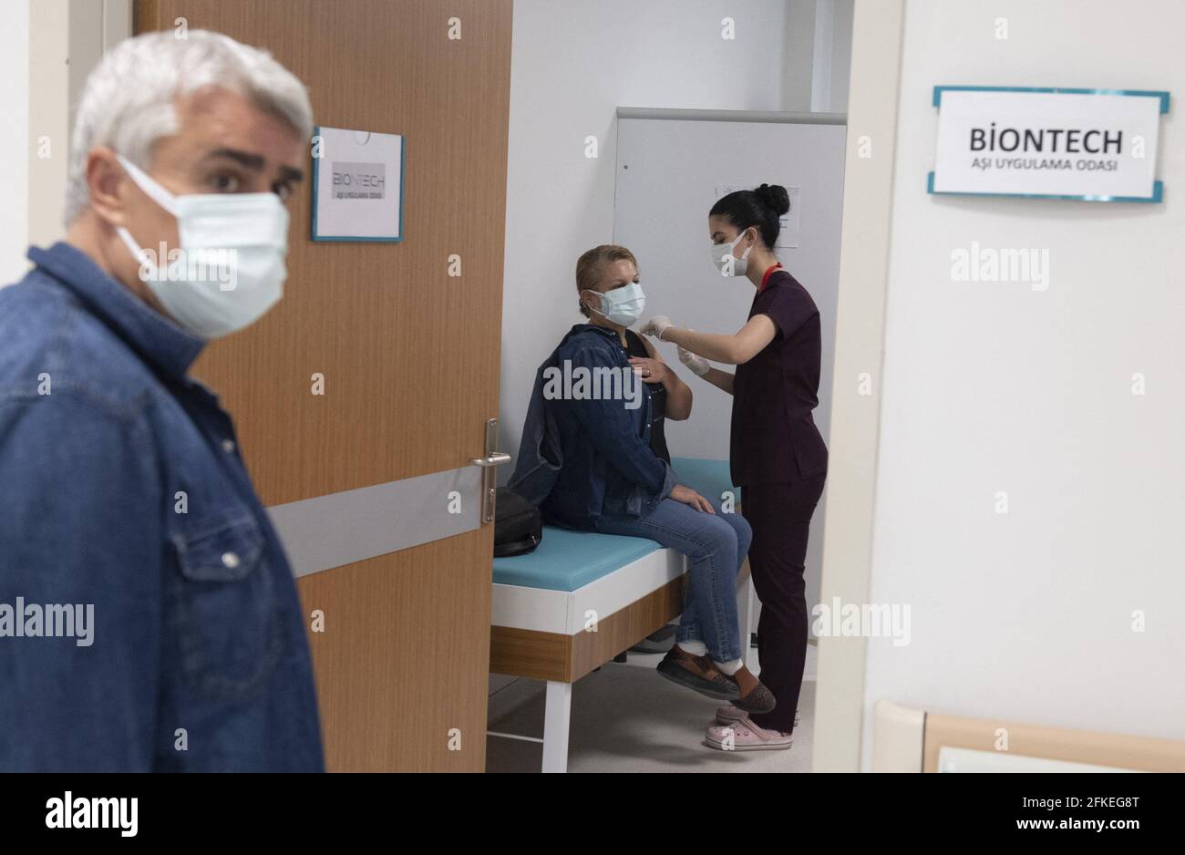 Turkish nurse vaccinates a woman against COVID-19 with Pfizer BioNTech ...