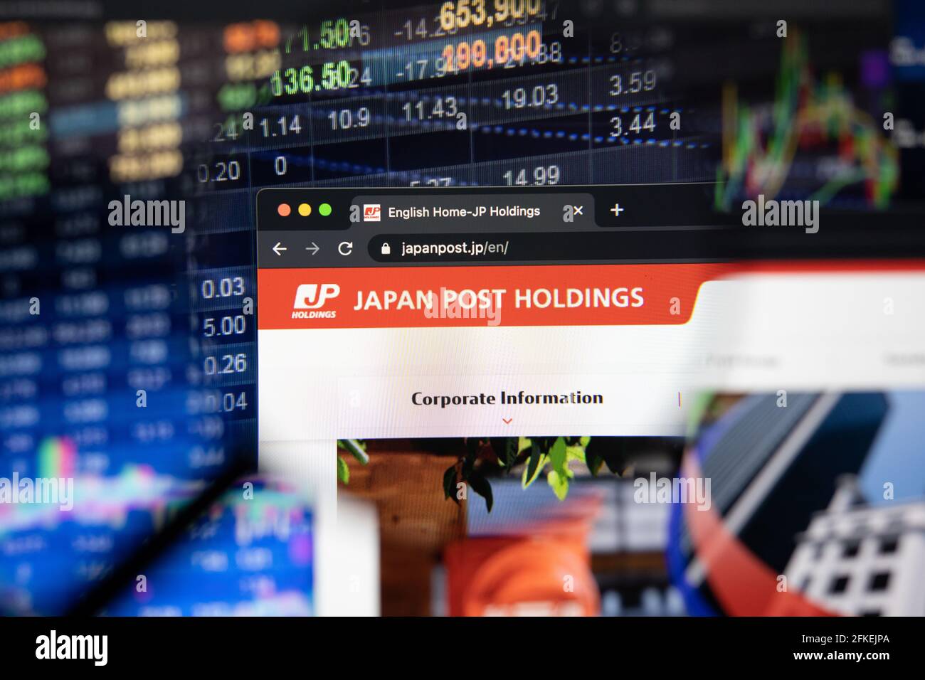 Japan Post Holding company logo on a website with blurry stock market developments in the ...