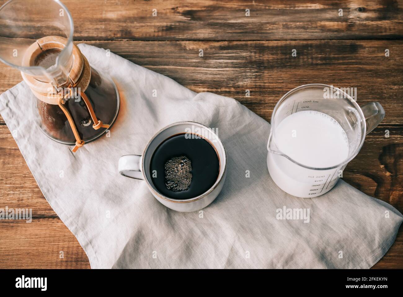 Coffee mug only on gray linen cloth with manual coffee pot and milk jug ...