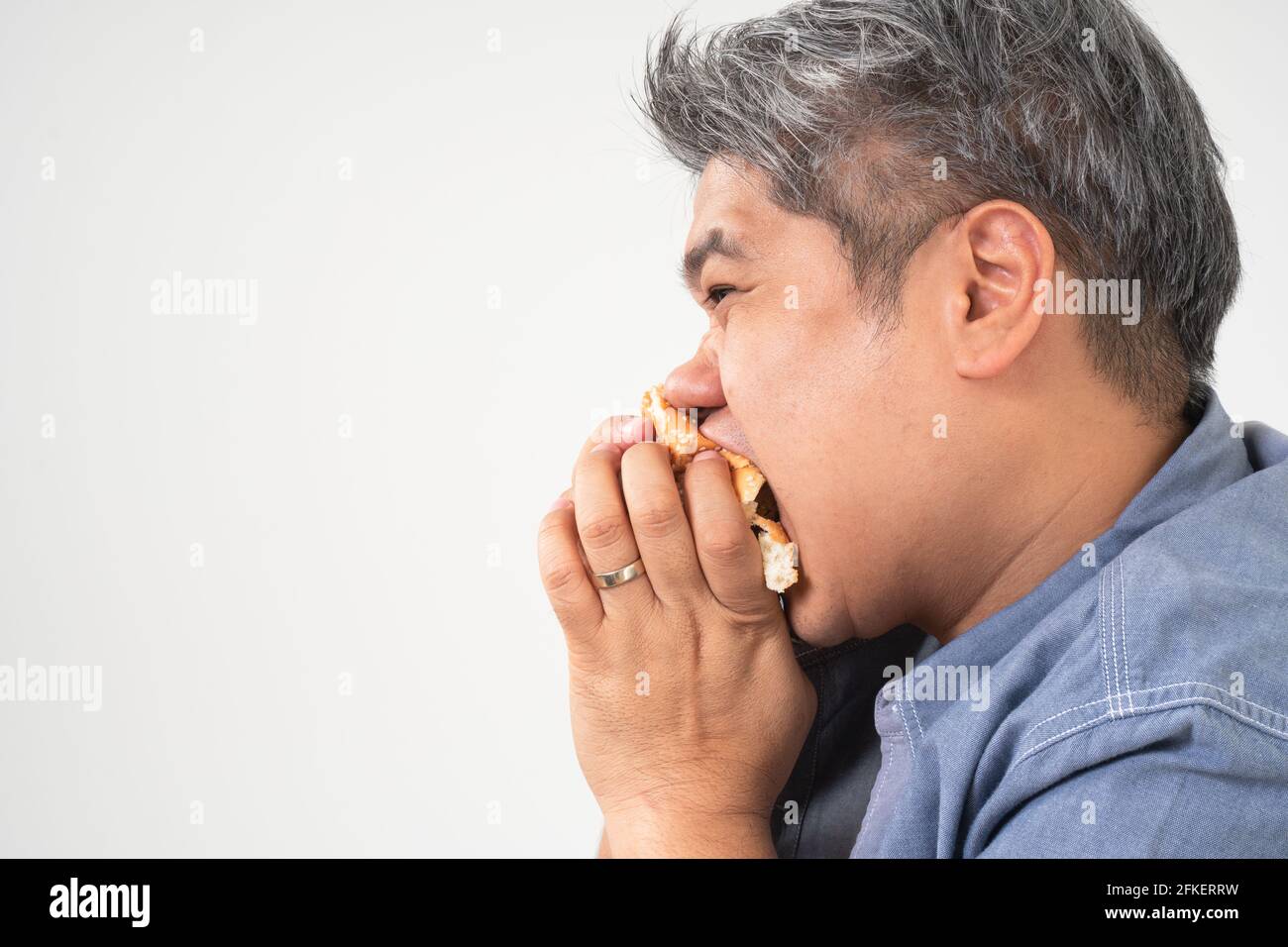 Asian Middle aged man holds and eating a hamburger deliciously Concept ...