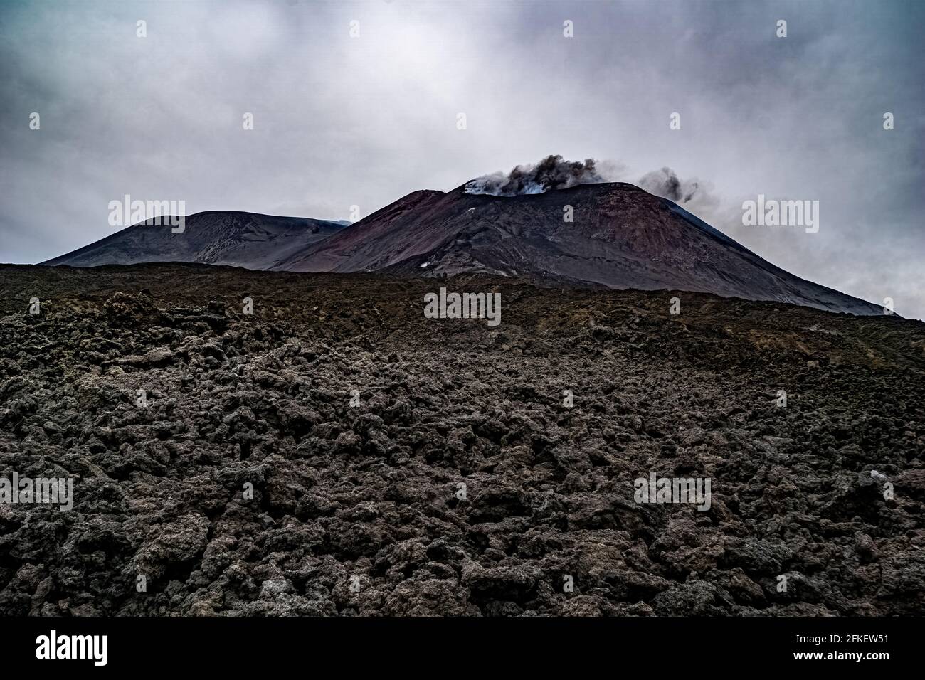 Low angle shot of the famous Etna volcano smoky and ashy top under a ...