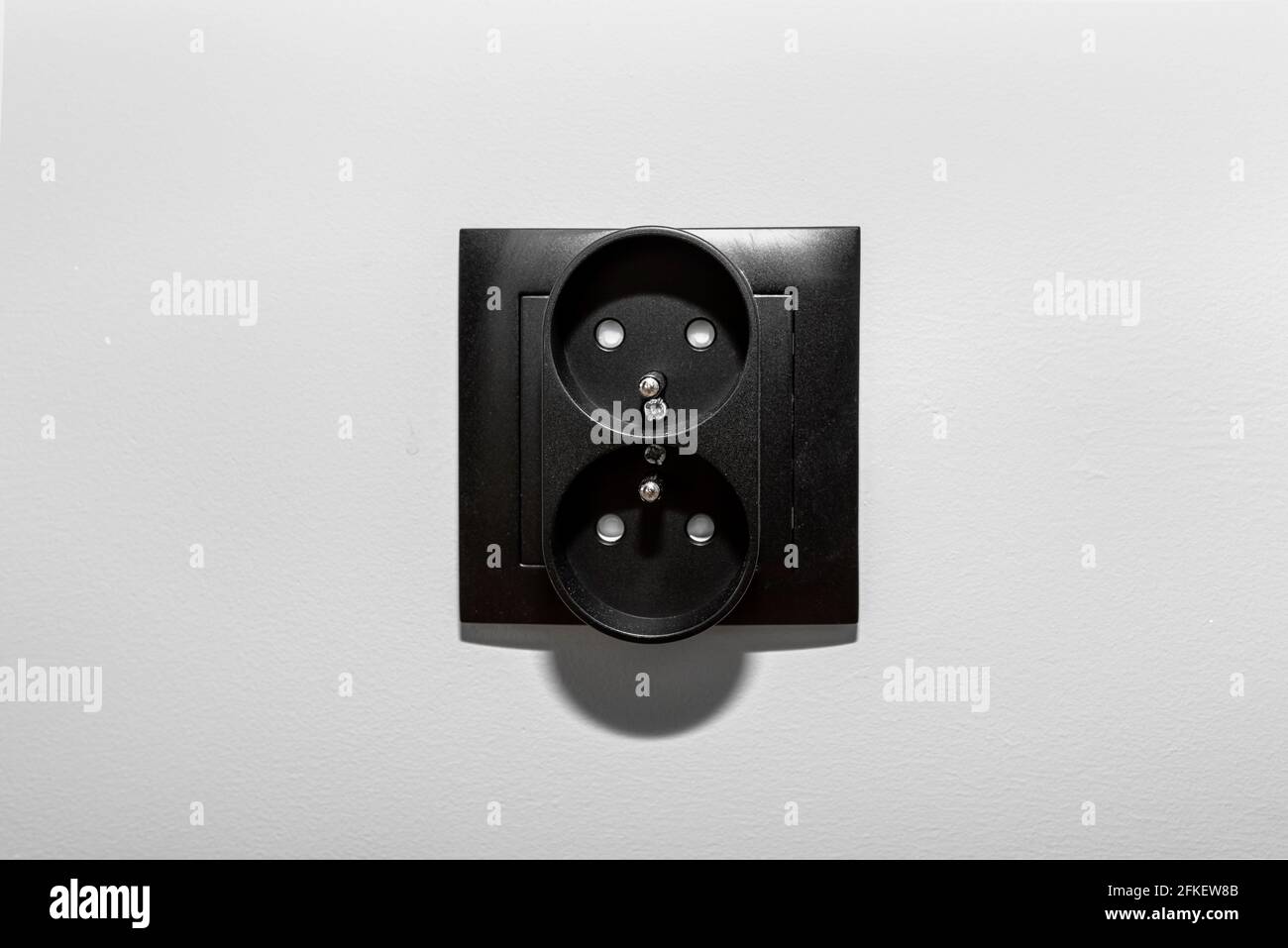 Black frame of a double electrical socket with grounding on the gray ...