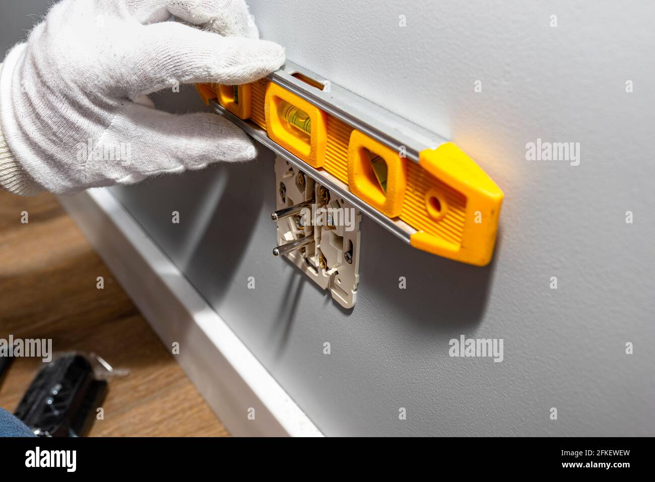 An electrician inserts a double grounded electrical outlet into the ...