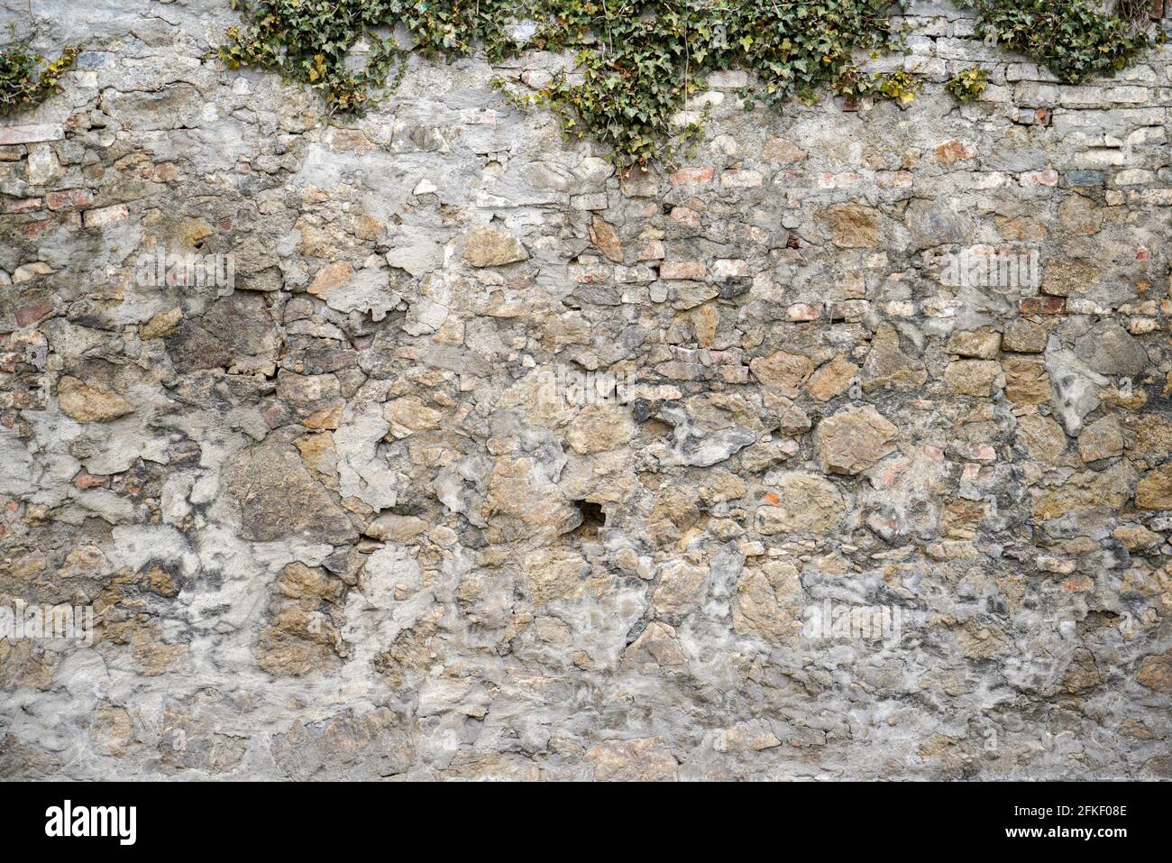 View at a stone wall with a small crack Stock Photo - Alamy