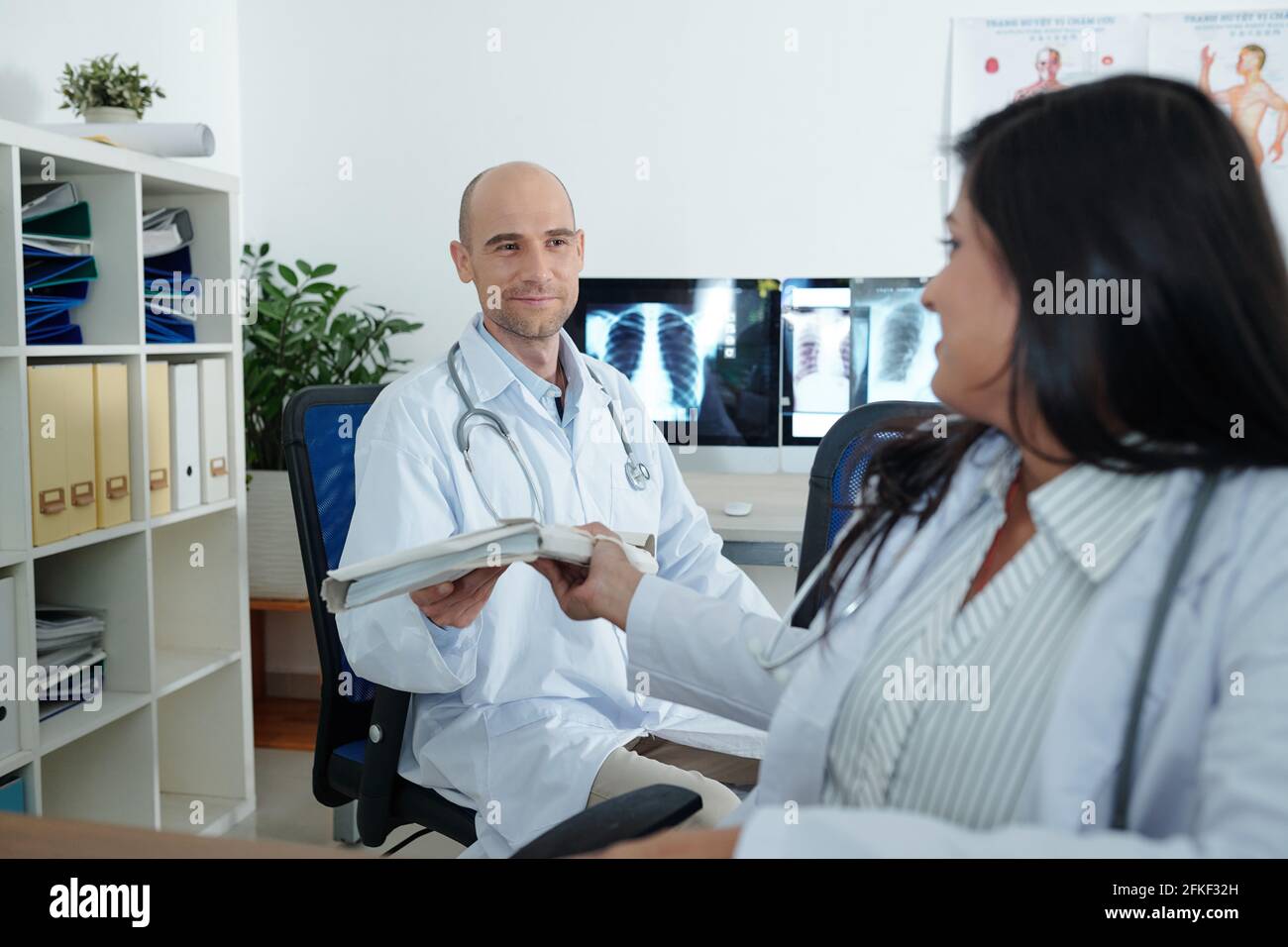 Doctor giving patient documents hi-res stock photography and images - Alamy