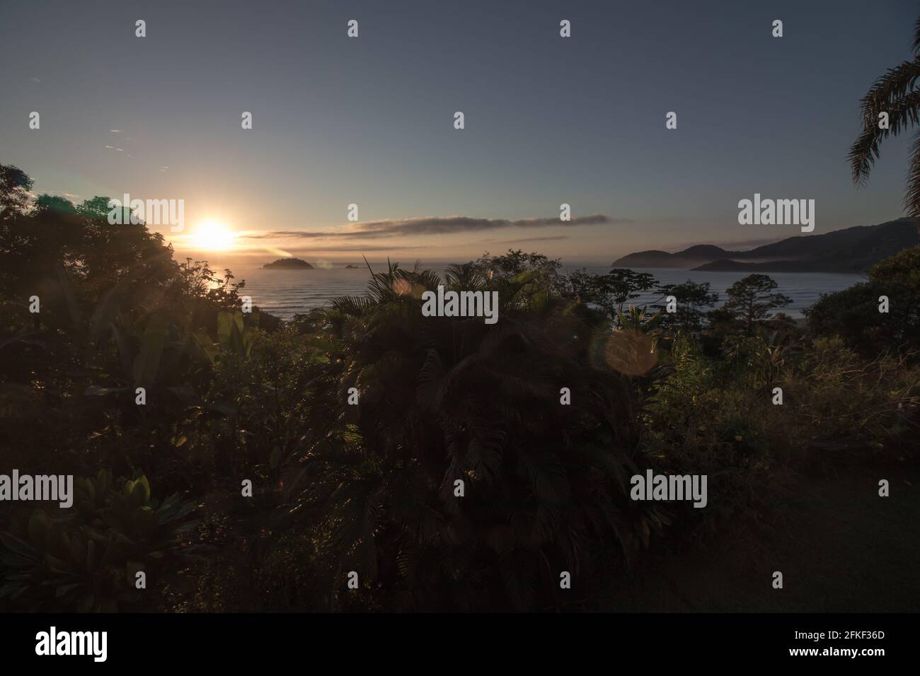 High view of the sun rising over the ocean and the nature Stock Photo ...