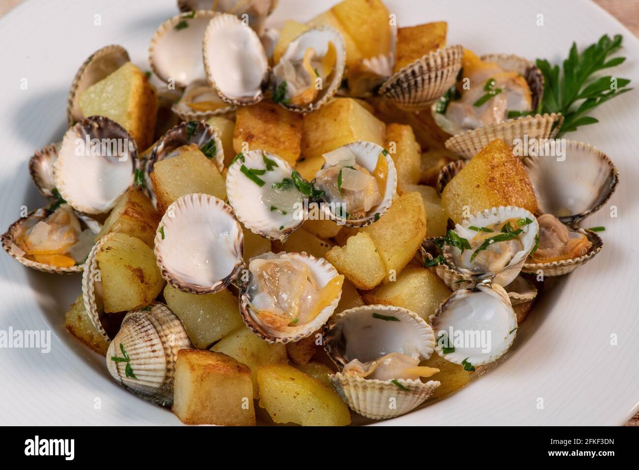 Steamed cockles with fried potatoes in the white dish, mariniere recipe ...