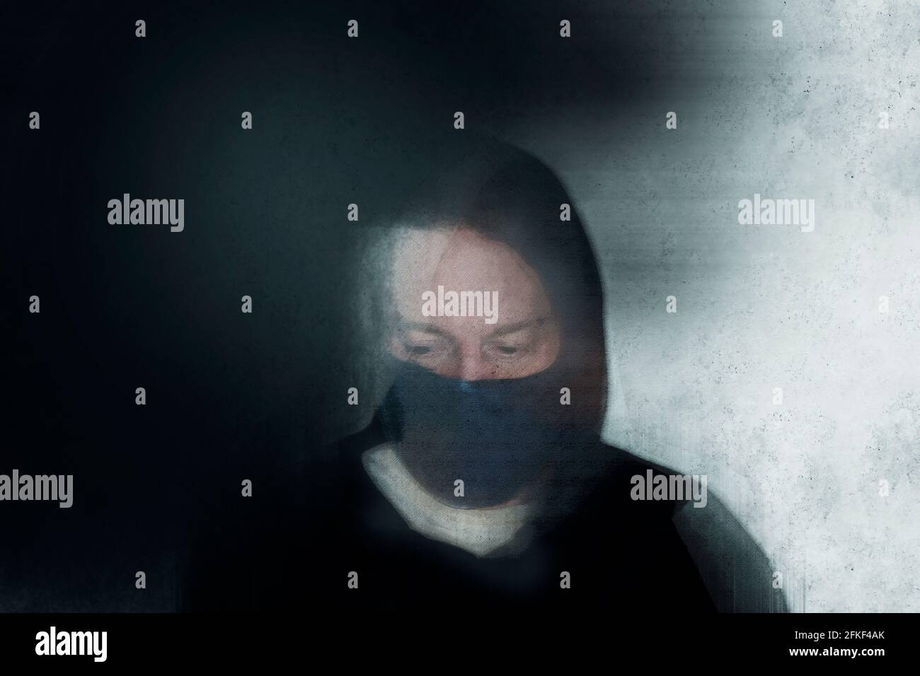 A mental health concept. Of a masked man looking down looking lonely ...