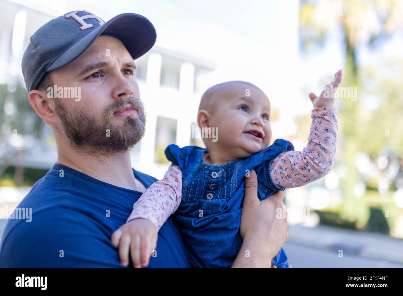 Bearded father holding his cute happy baby with blurry background Stock ...