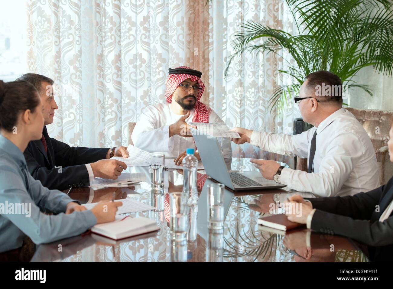 A multi ethnic group of people around a table hi-res stock photography ...