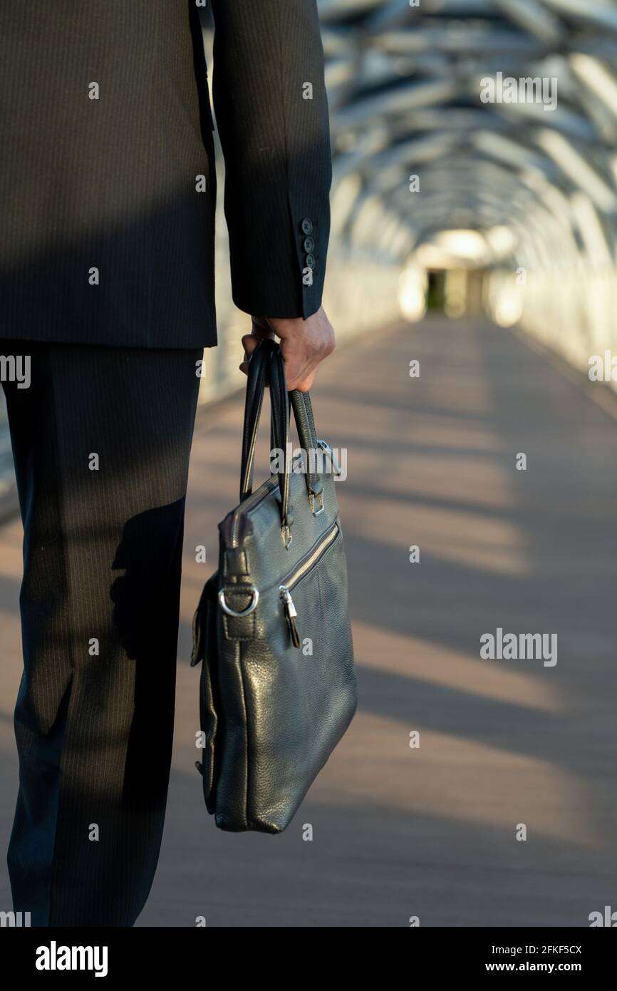 A person carrying black leather handbag in front of camera Stock Photo ...