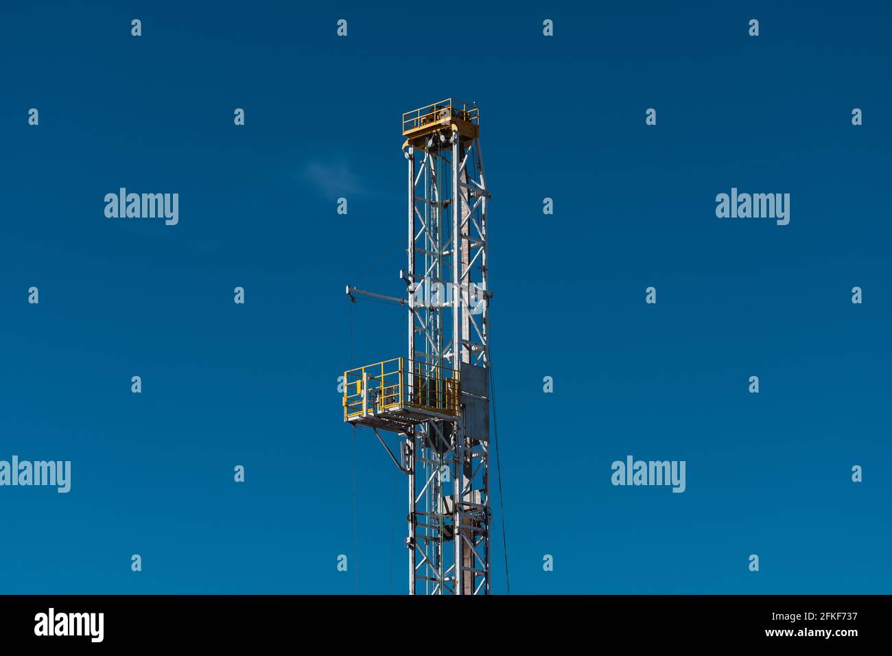Closeup shot of the top of drilling towers with blue sky in the ...