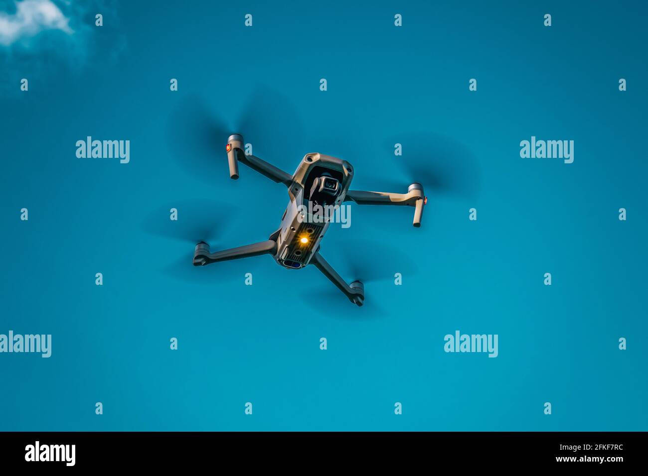 Drone flying overhead in cloudy blue sky Stock Photo - Alamy