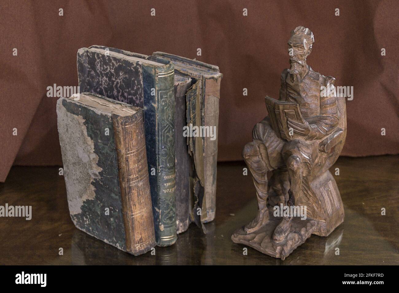 Three ancient stained books by a statue of a philosopher Stock Photo ...