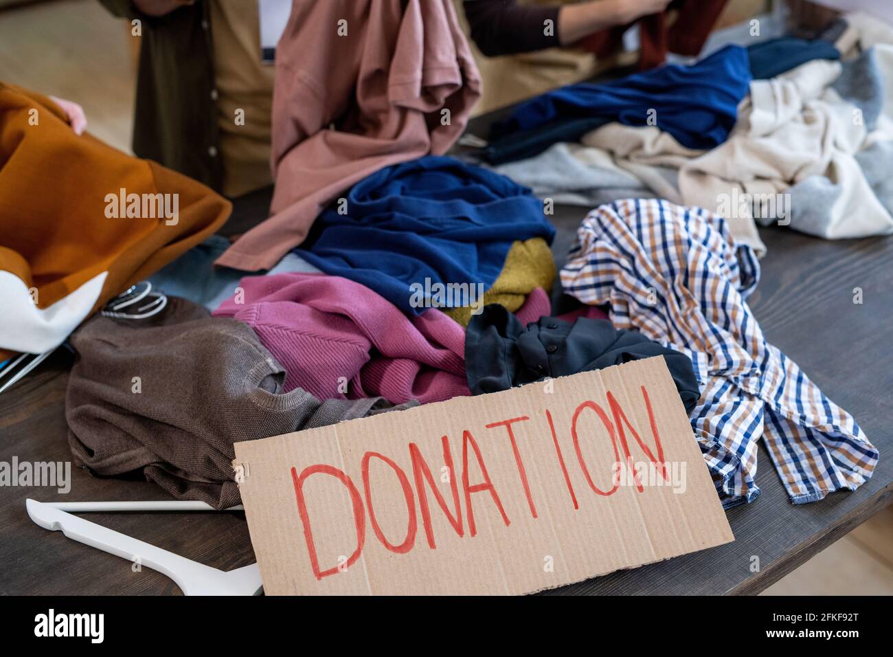 A heap of donation clothes on black wooden table Stock Photo - Alamy
