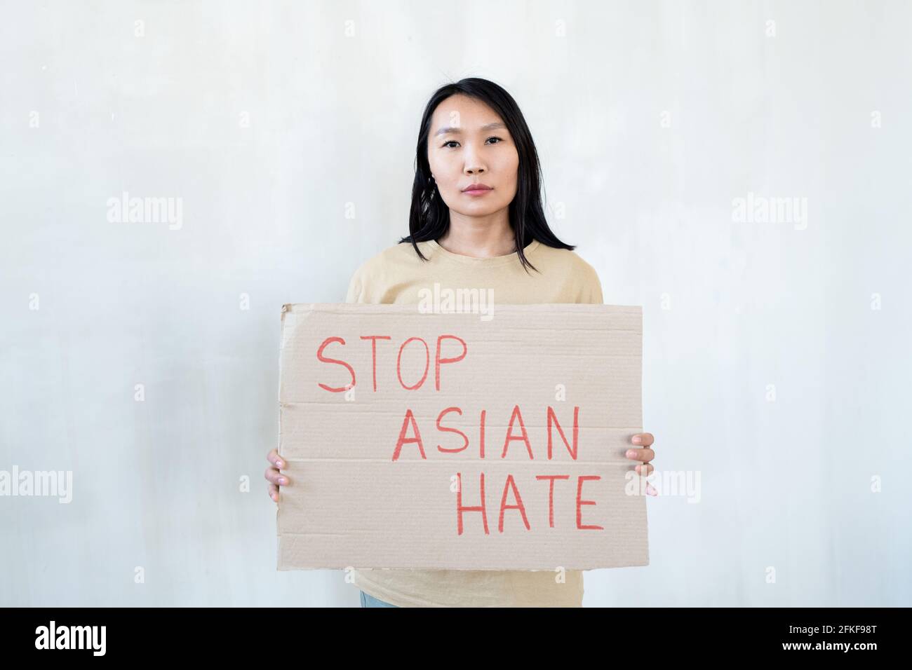 Asian female with paper announcing protest against national ...