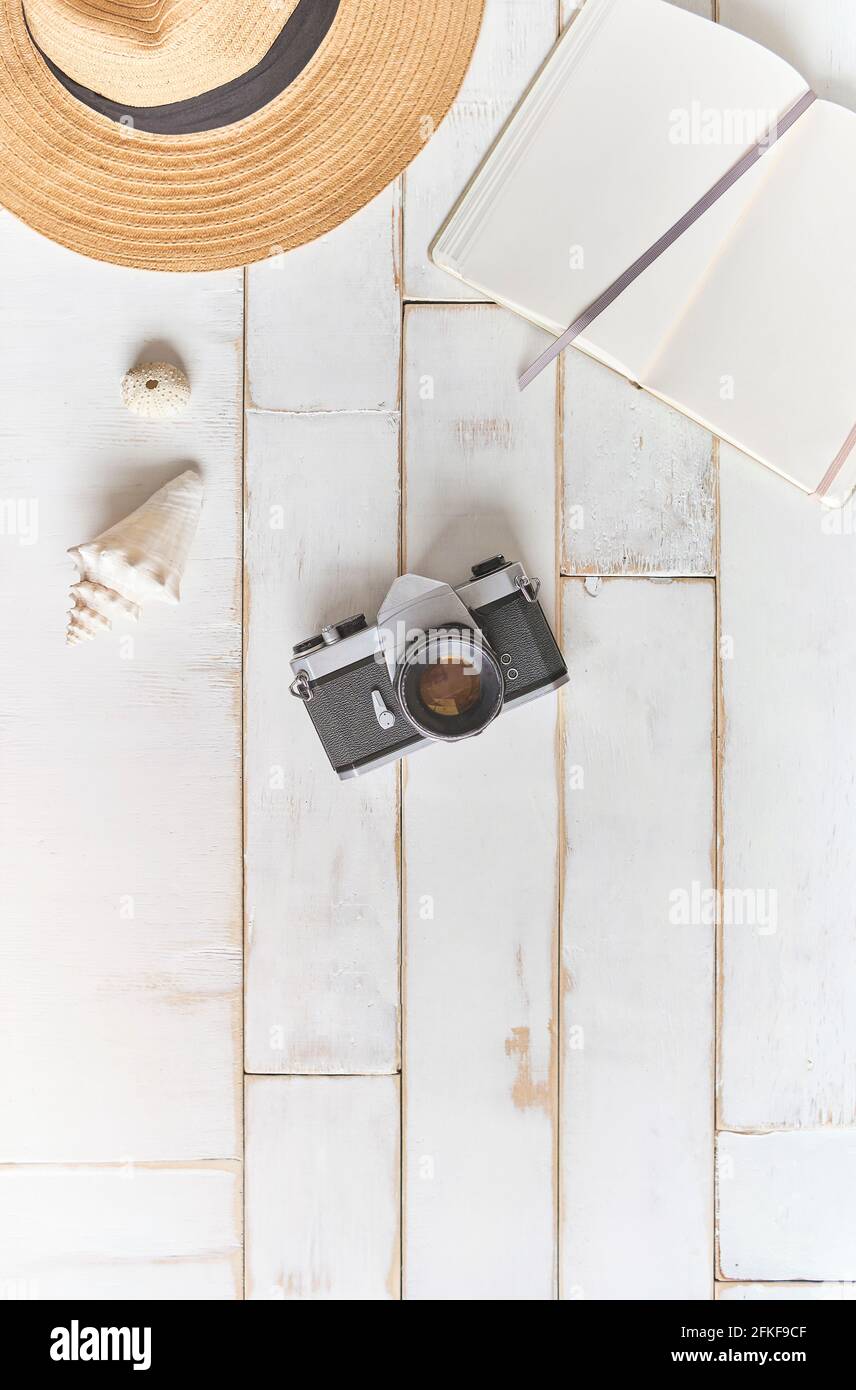 Top view of an analog camera and a notebook on a wooden table ...