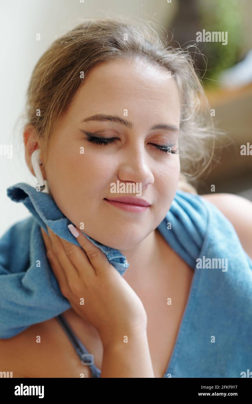 Face of pretty smiling young woman wiping off sweat after intense at ...