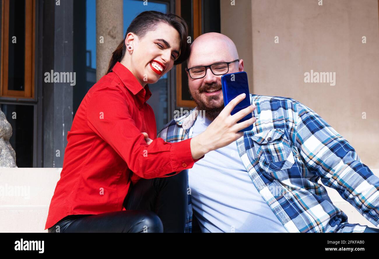 A transgender / non-binary girl with a friend, taking a selfie ...