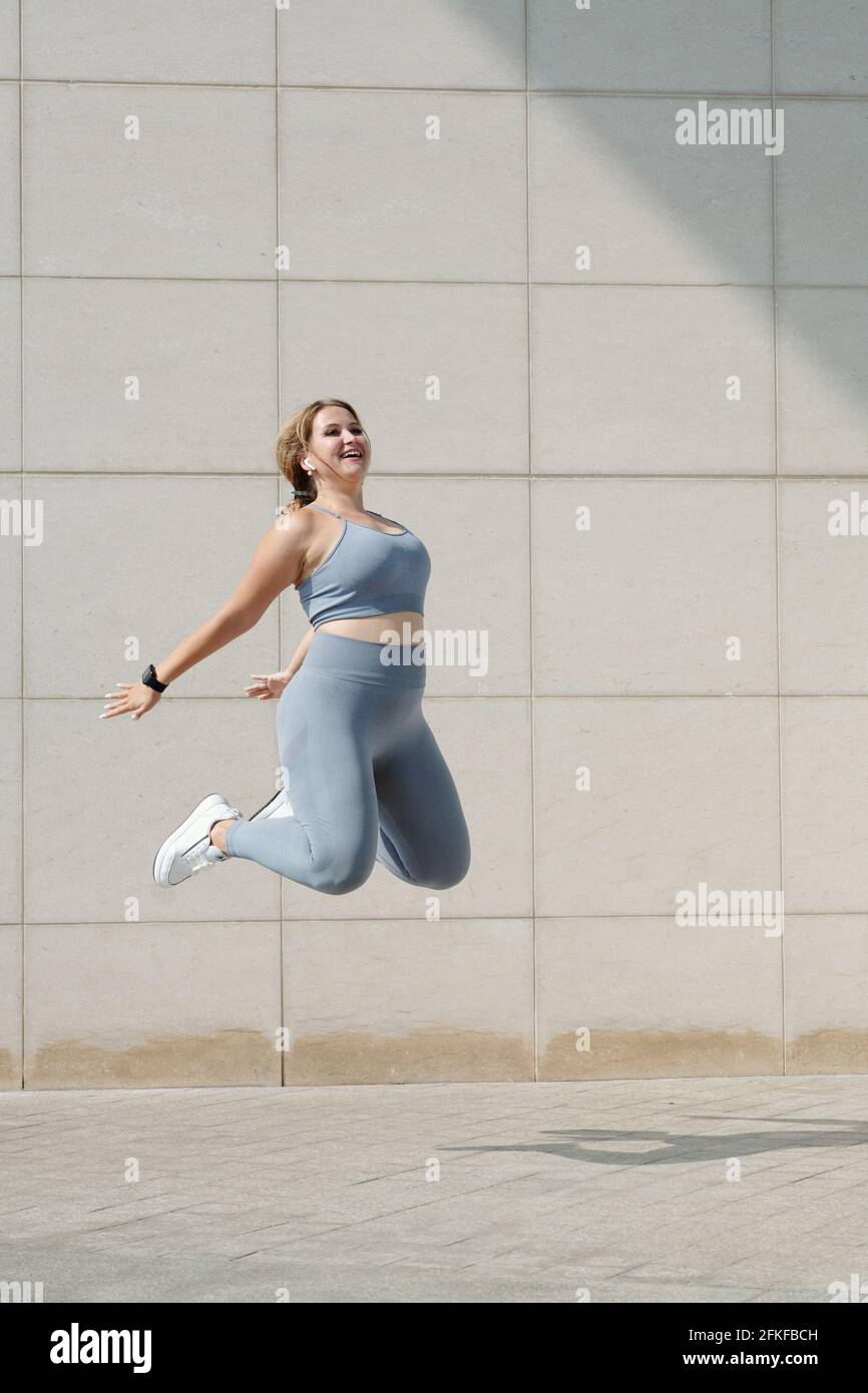 Happy excited young plus size woman jumping high, healthy lifestyle and ...