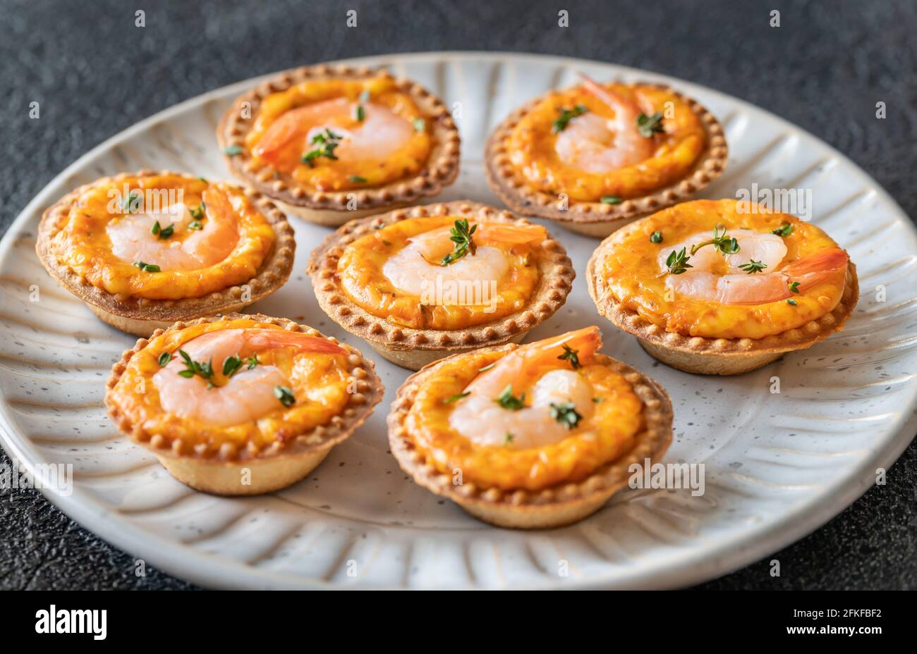 Portion of shrimp tartlets with cheesy sauce Stock Photo - Alamy