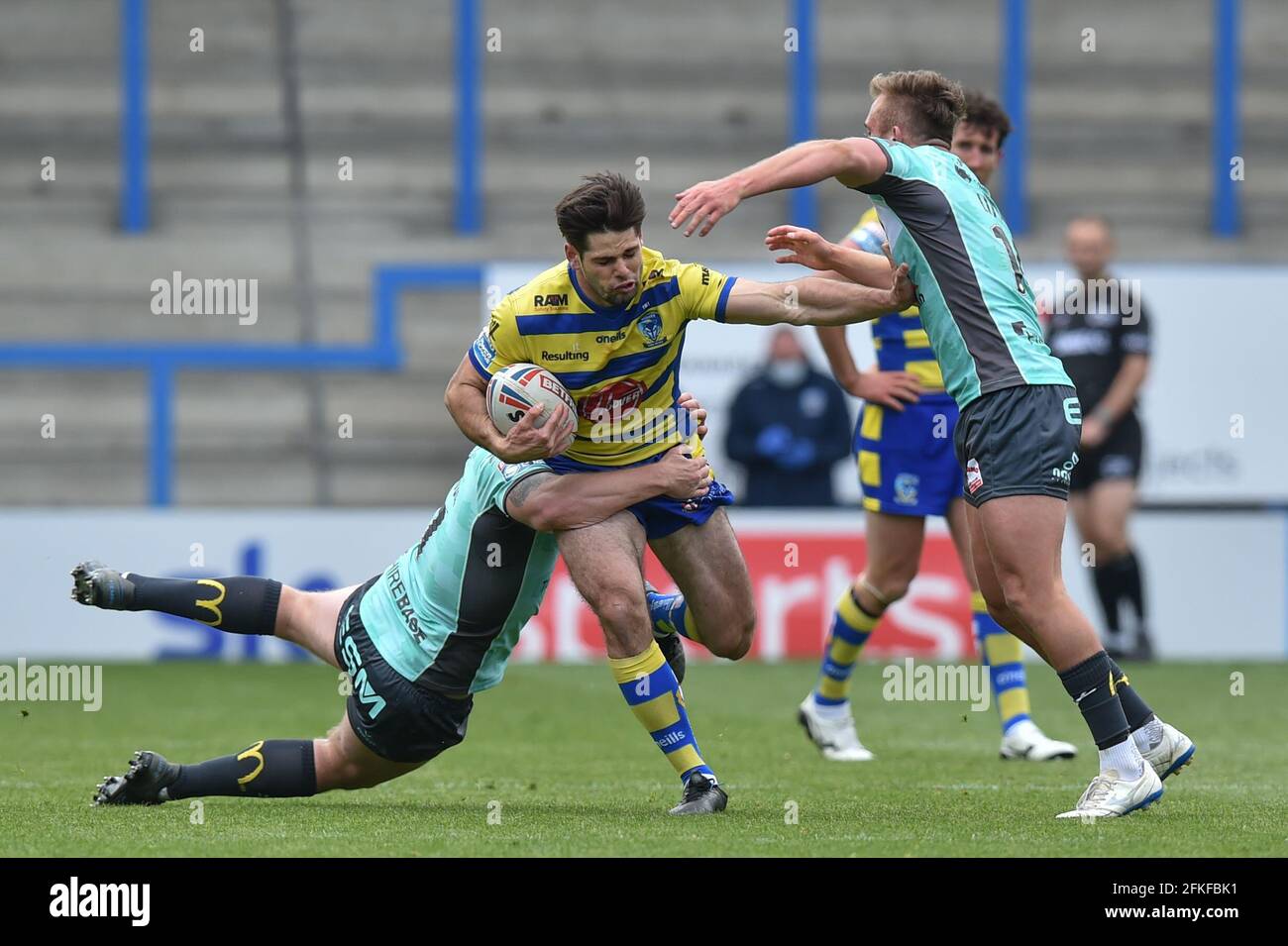 Jake Mamo (18) of Warrington Wolves in the tackle of Adam Quinlan (1 ...