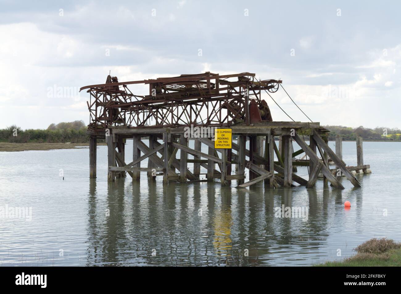 Alresford Creek, Essex, remains of the ballast barge jetty on calm ...