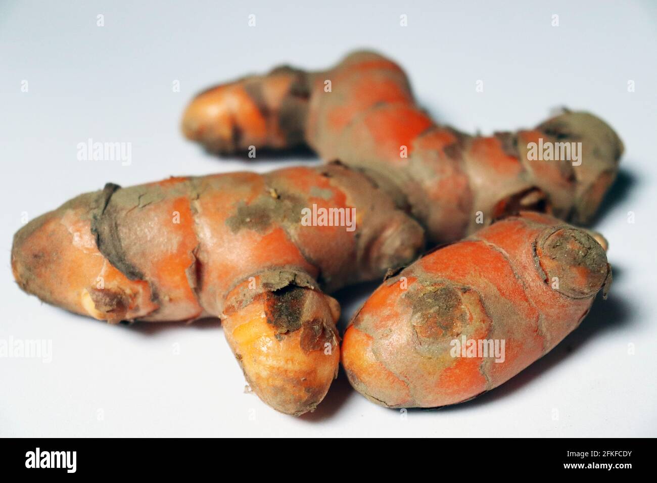 yellow colored raw turmeric closeup on white background Stock Photo - Alamy