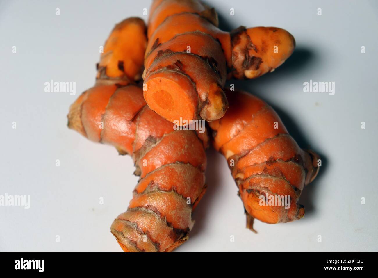 yellow colored raw turmeric closeup on white background Stock Photo - Alamy