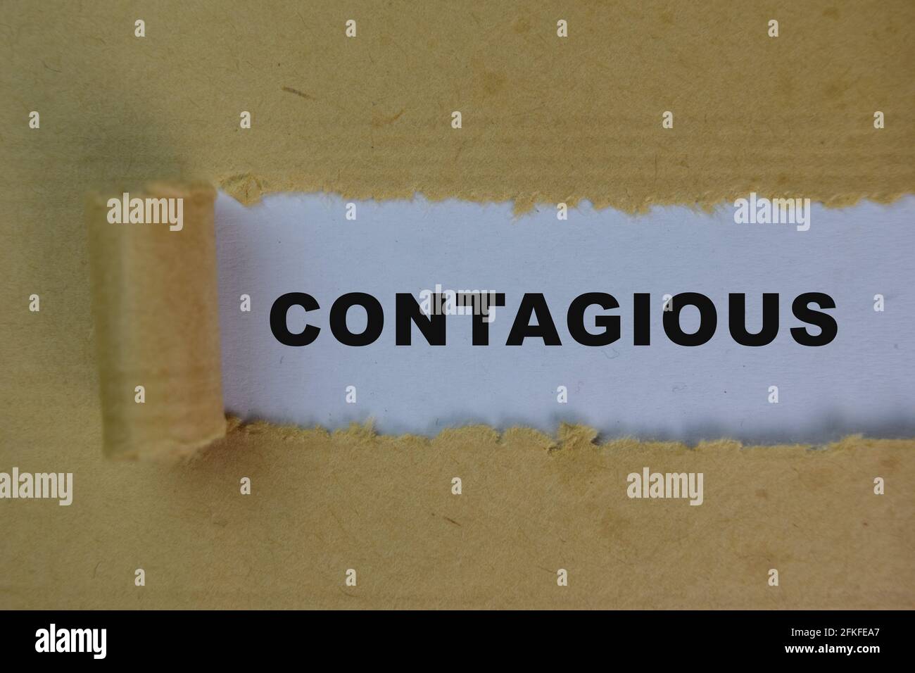 Contagious Text written in torn paper Stock Photo - Alamy