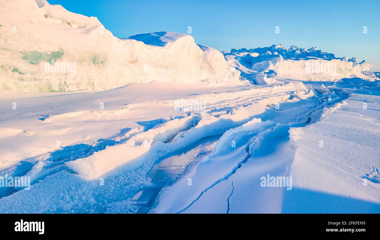 Melting sea ice cracked with water flowing next to old sea ice in ...