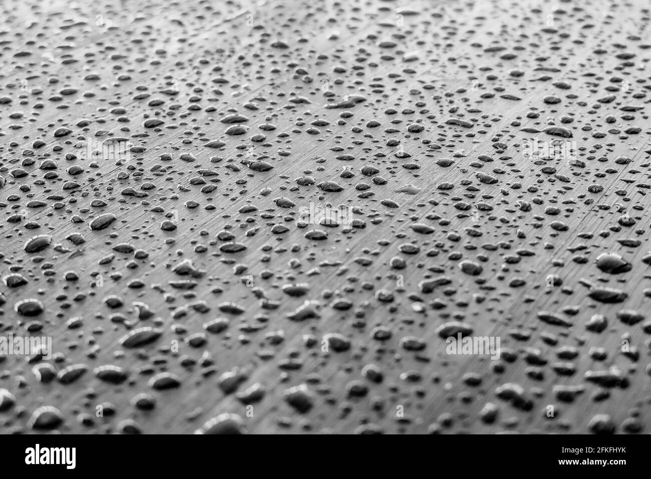 Closeup of raindrops on the dark gray surface Stock Photo - Alamy