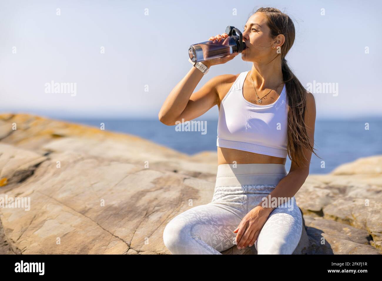 Female Athlete Drinking Water During Outdoor Workout by the Sea Stock ...