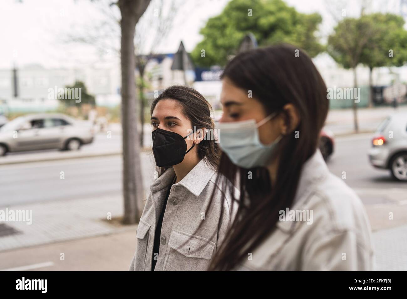 Spanish girls in protective face masks are walking outside Stock Photo ...