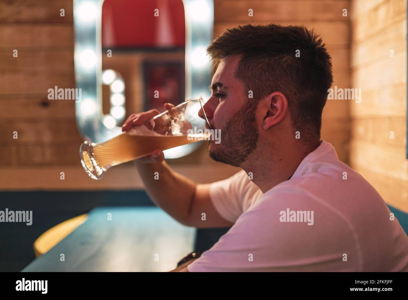 Side view of a young European male drinking beer in the pub Stock Photo ...