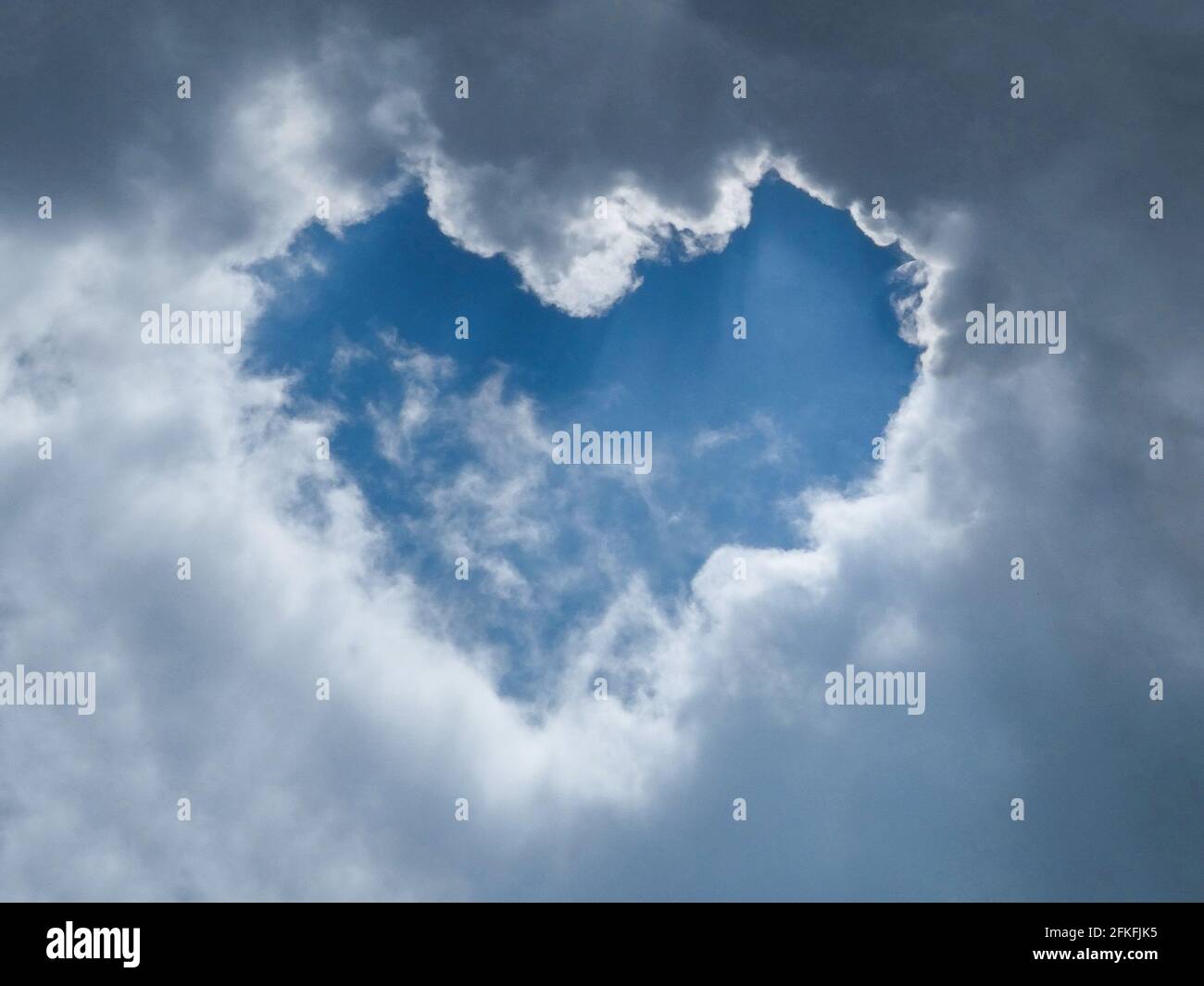 Beautiful hole in the clouds in the shape of a heart; love and romance ...