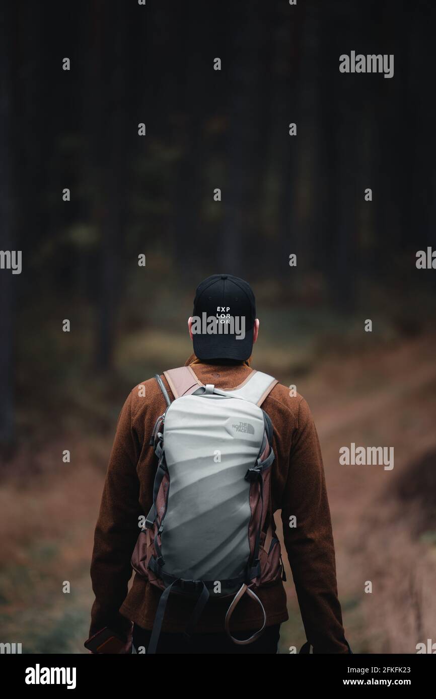 Back view of a tourist with a backpack and a cap with a message to ...