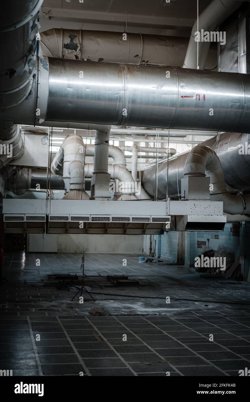 Vertical shot of a factory tiled room with big rusty pipes Stock Photo ...