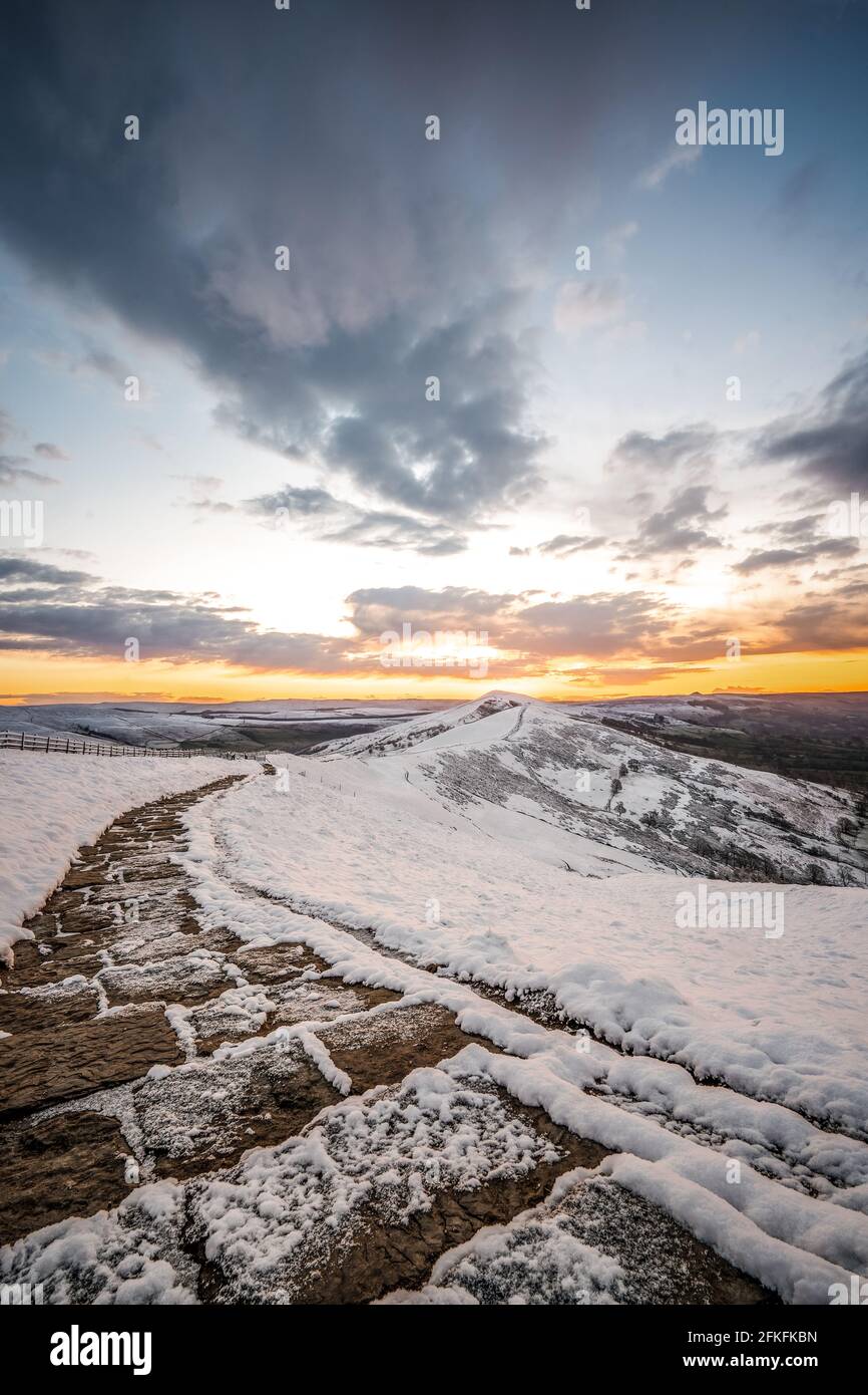 Sun below the horizon icy frozen snow covered winding stone footpath ...