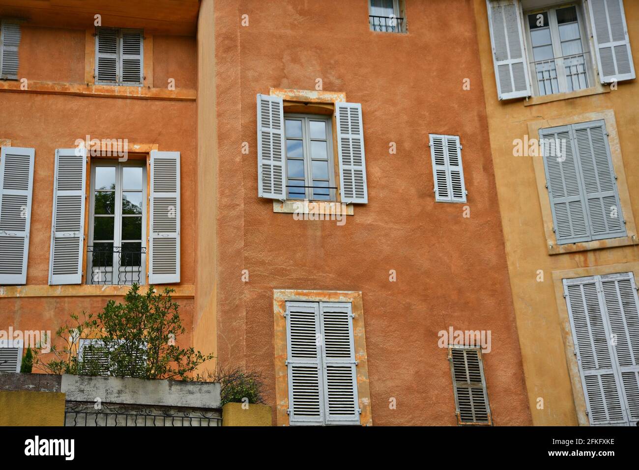 Traditional Provençal style house facade with an ochre stucco wall and ...