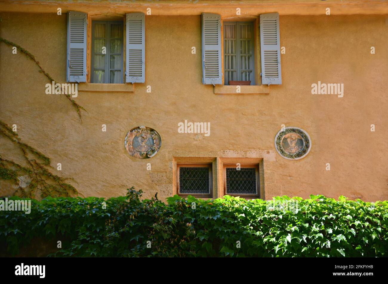 Traditional Provençal style house facade with an ochre stucco wall and ...