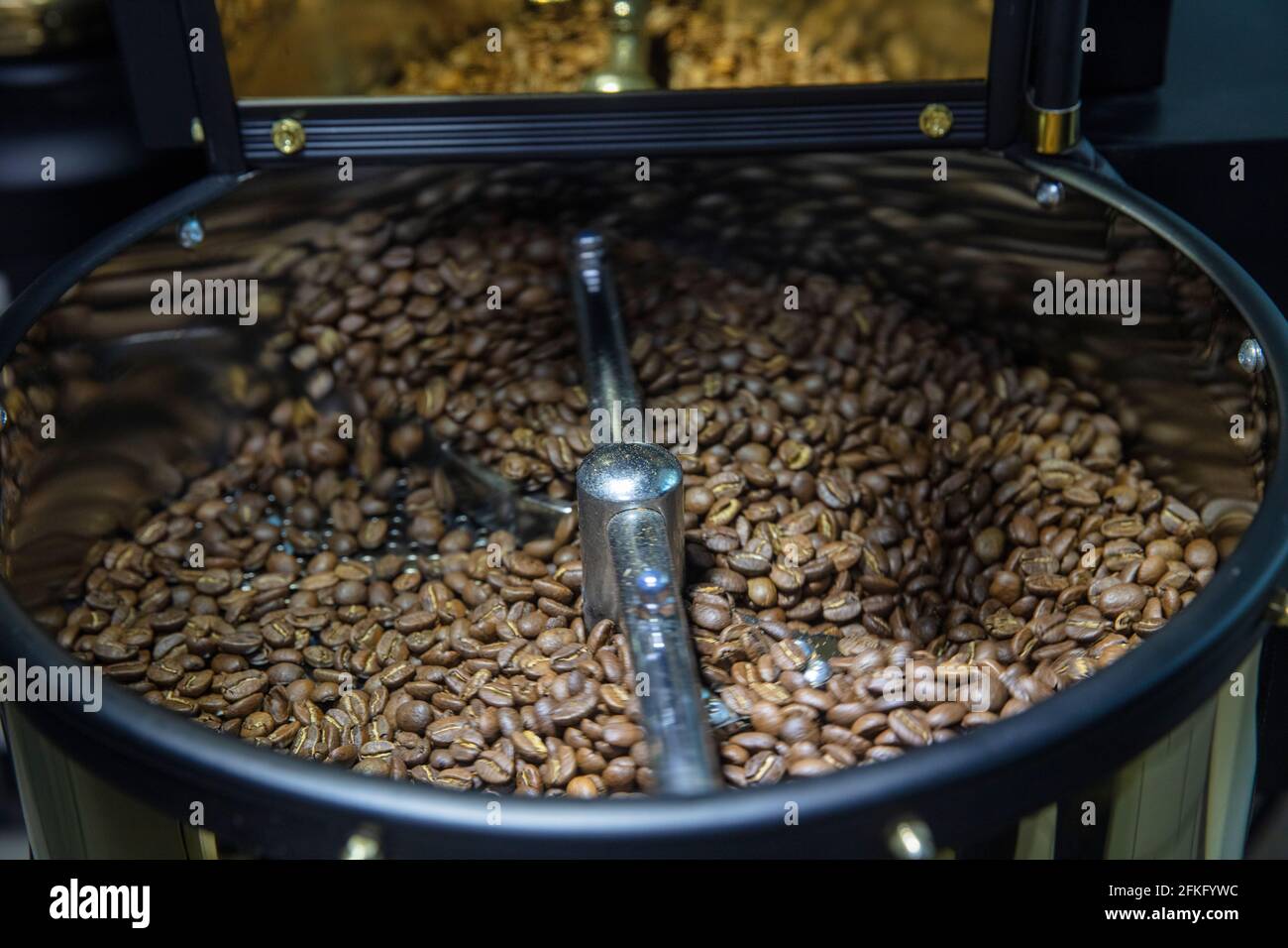 Coffee Roaster. Roasting coffee beans hand close up. Top view near ...
