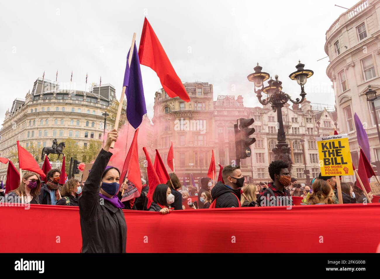 London, UK. 01st May, 2021. Protestors raise purple and red flags, as ...