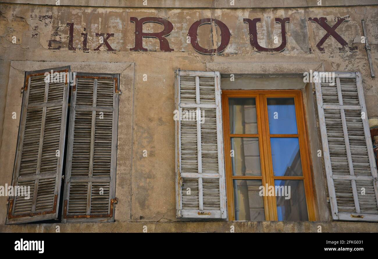 Commercial building facade with a faded stucco wall, wooden window ...