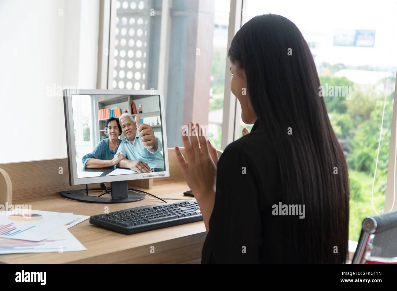 Asian parents are video conference with daughter during vacation ...