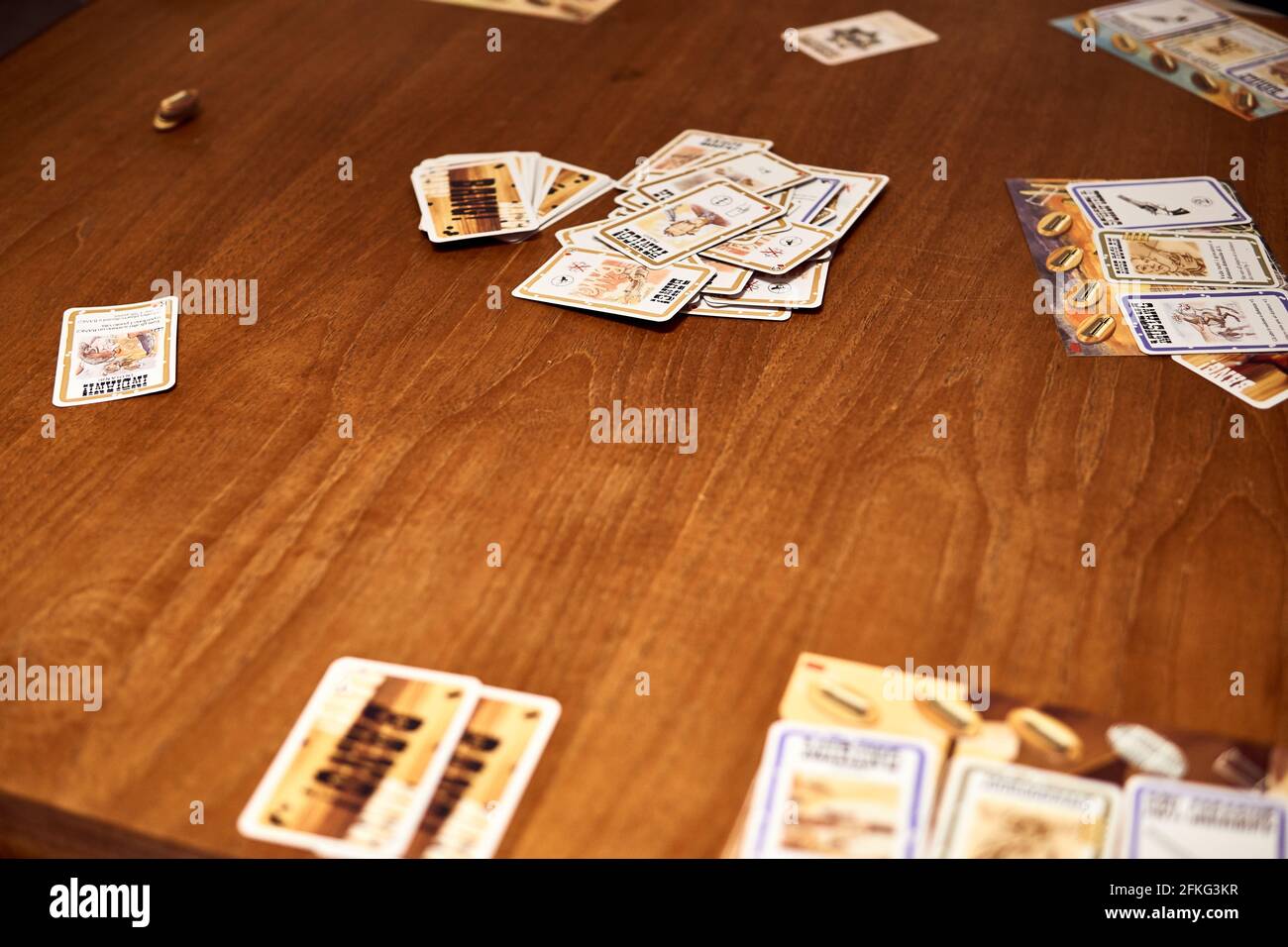 Wooden table with playing cards during a game Stock Photo - Alamy