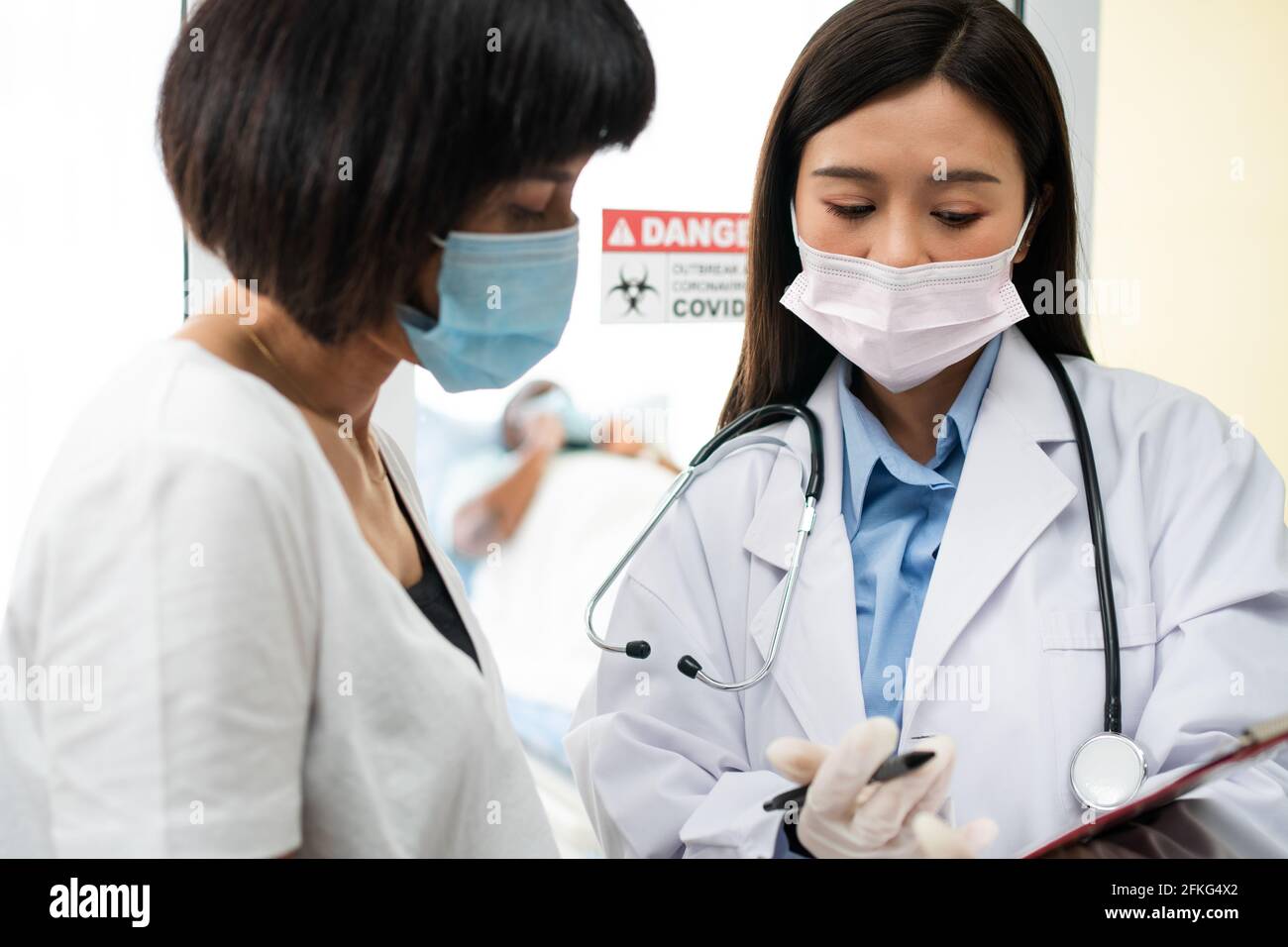 Asian doctor standing in front Quarantine room of and explaining ...