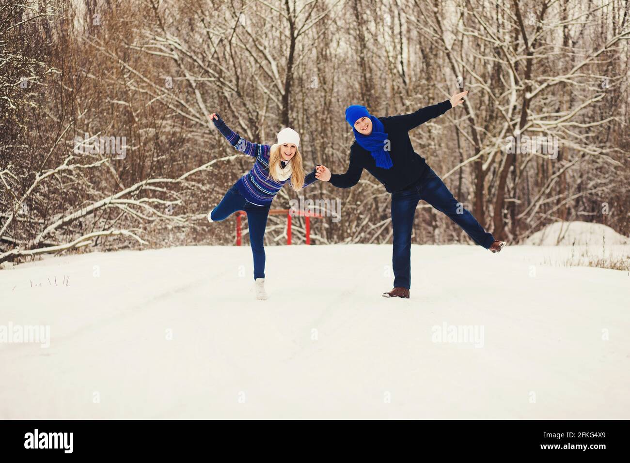 Positive couple playing in the snow park Stock Photo - Alamy