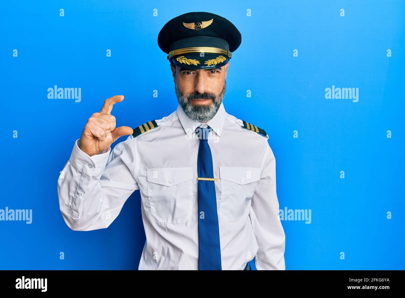 Middle age man with beard and grey hair wearing airplane pilot uniform ...